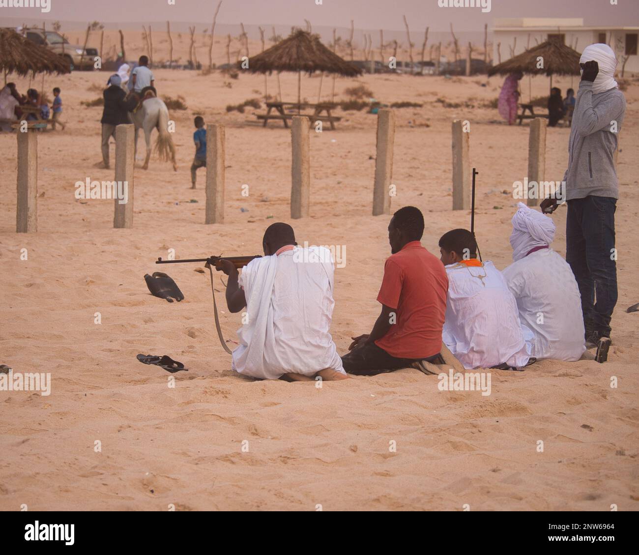 Men playing with an air gun to a typical local game in Nouakchott beach ...