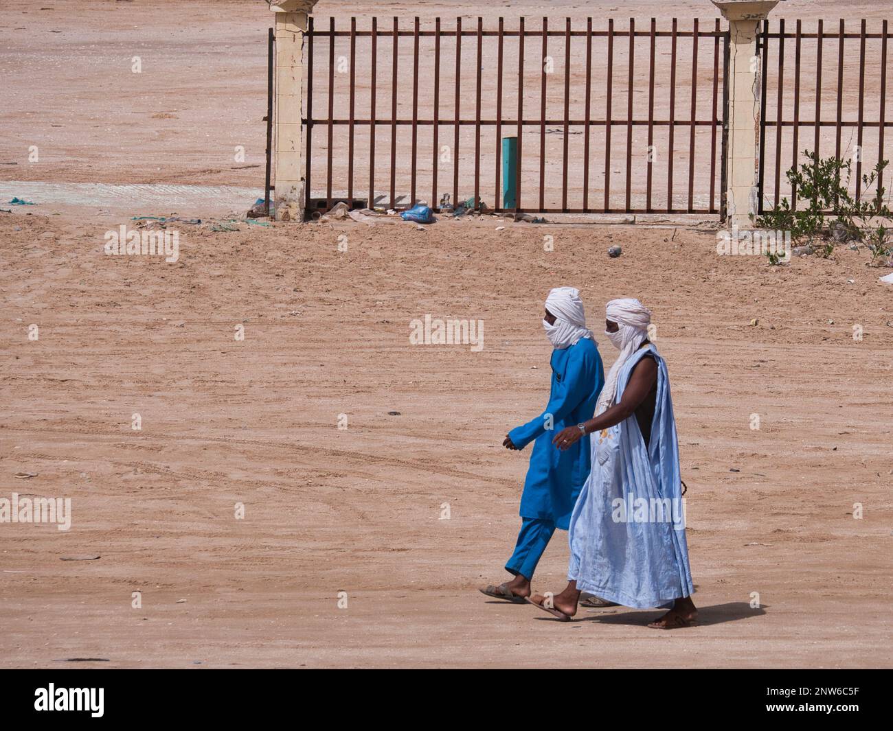 Two men wearing daraa clothes walking down the street Stock Photo - Alamy