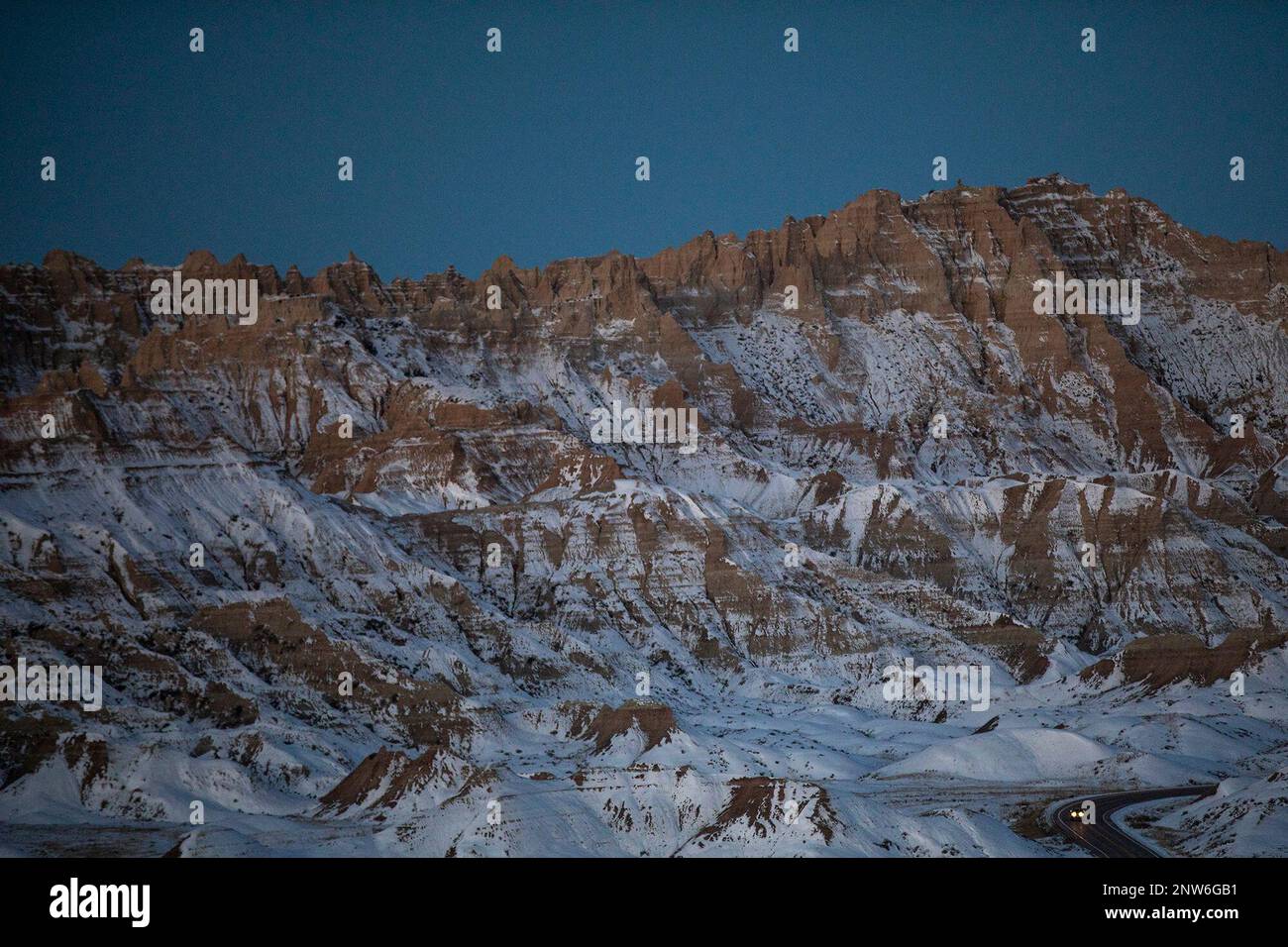 A vehicle drives along South Dakota Highway 240 in Badlands National ...