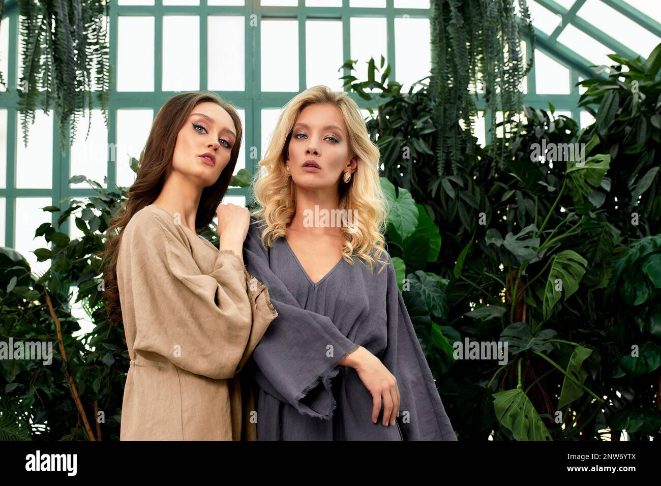 Portrait of two beautiful caucasian girls models in the greenhouse ...