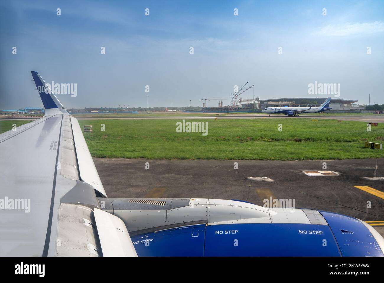 Airplanes ready for departure with clear blue sky and lush green runway ...