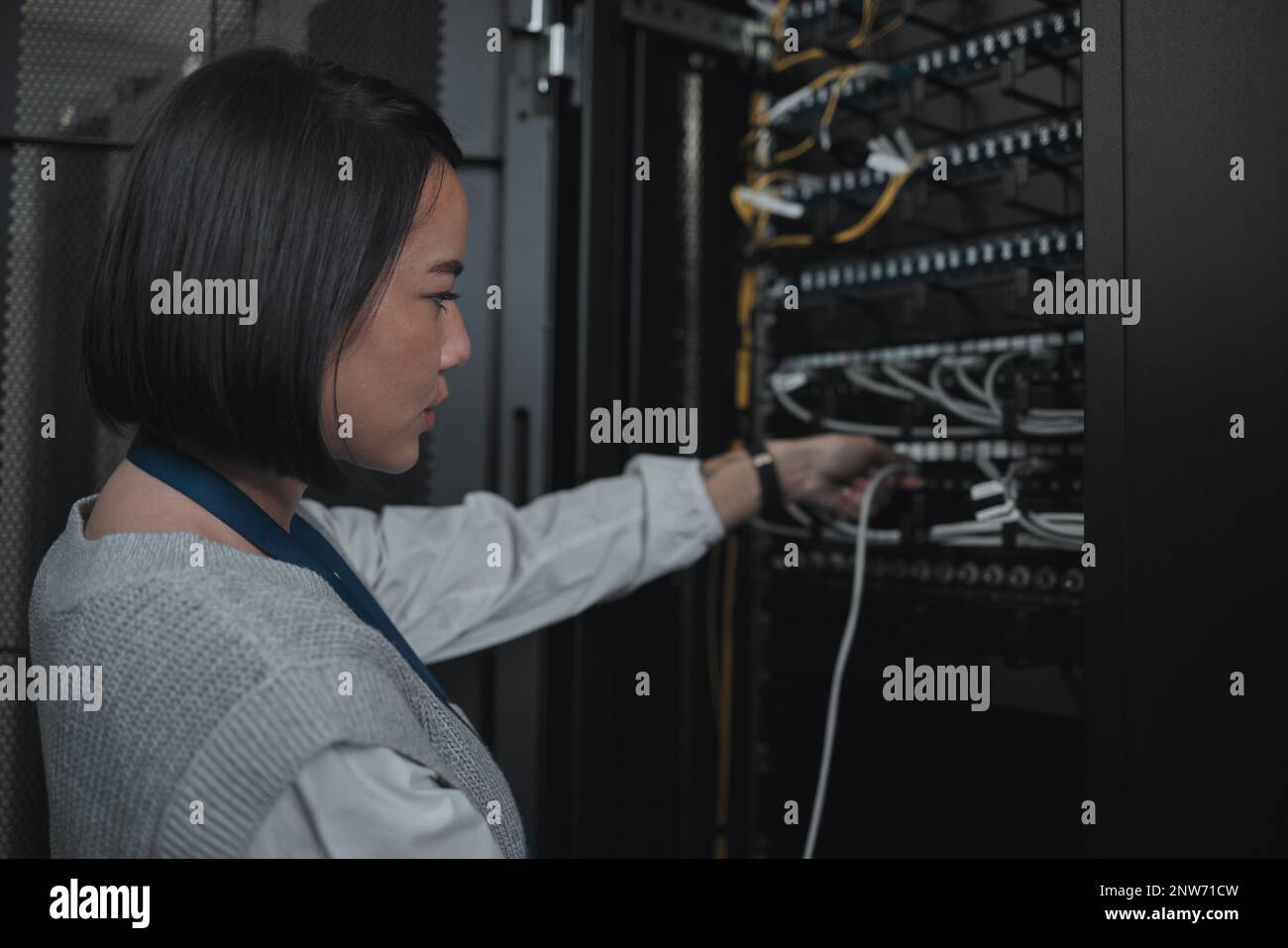Asian woman, technician and server room for cabling, networking or ...