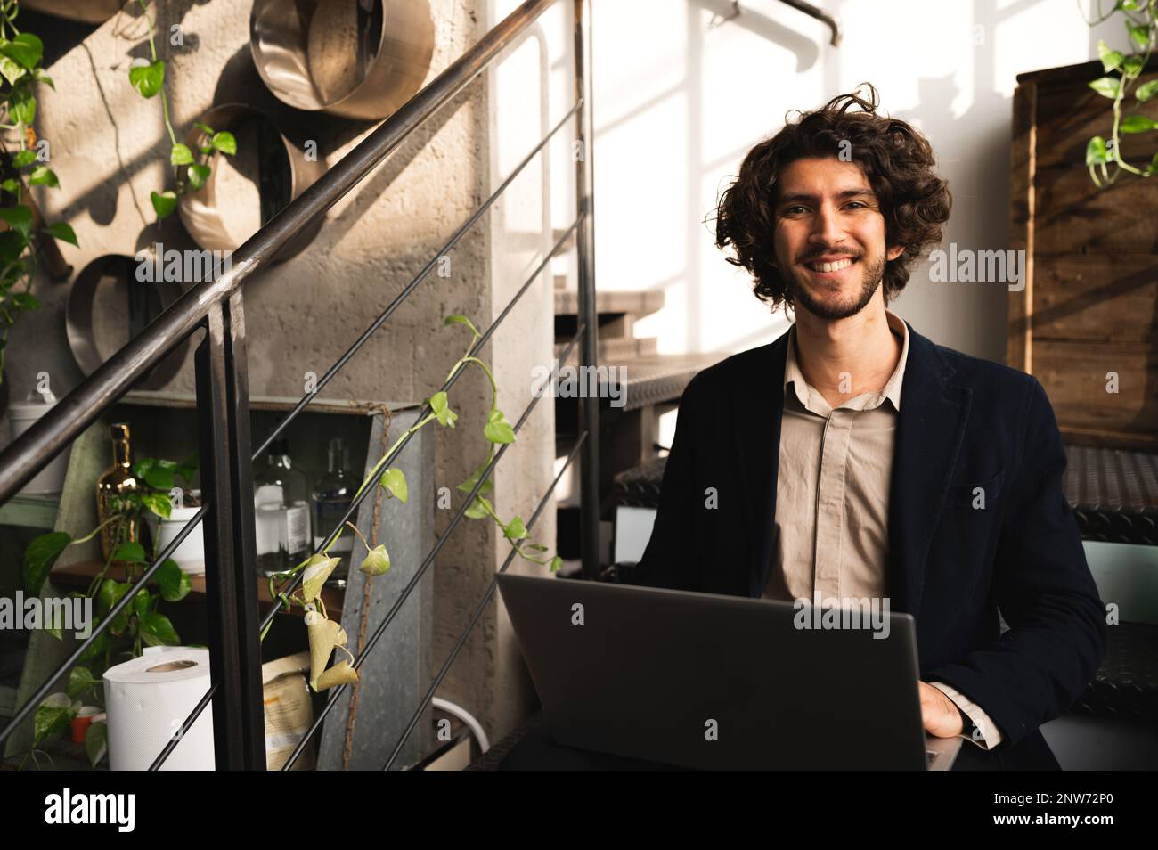 Hipster student posing at camera smiling. Guy sitting on a stair in a ...