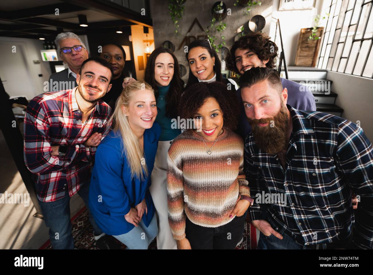 Wide angle portrait with group of mixed race and age looking at camera ...