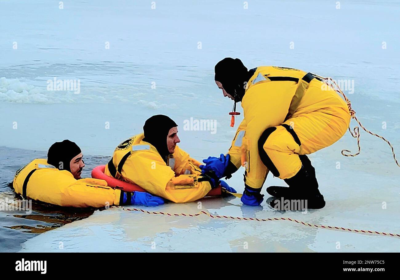 Firefighters wearing cold-water immersion protective suits hold surface ...