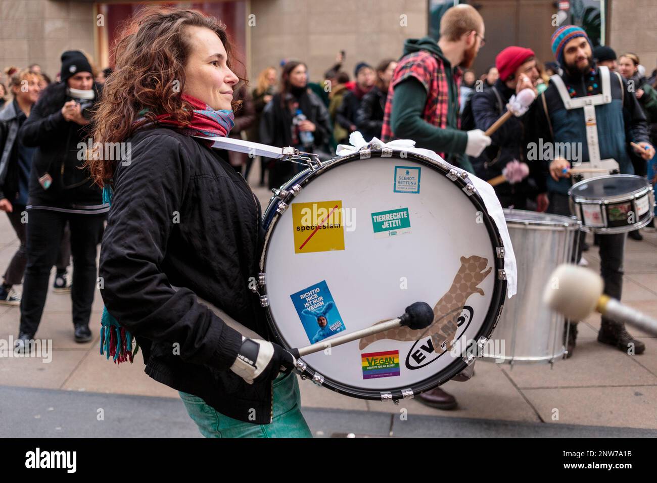 Berlin, Germany 3/8/2020 A woman carrying a bass drum marches and plays ...