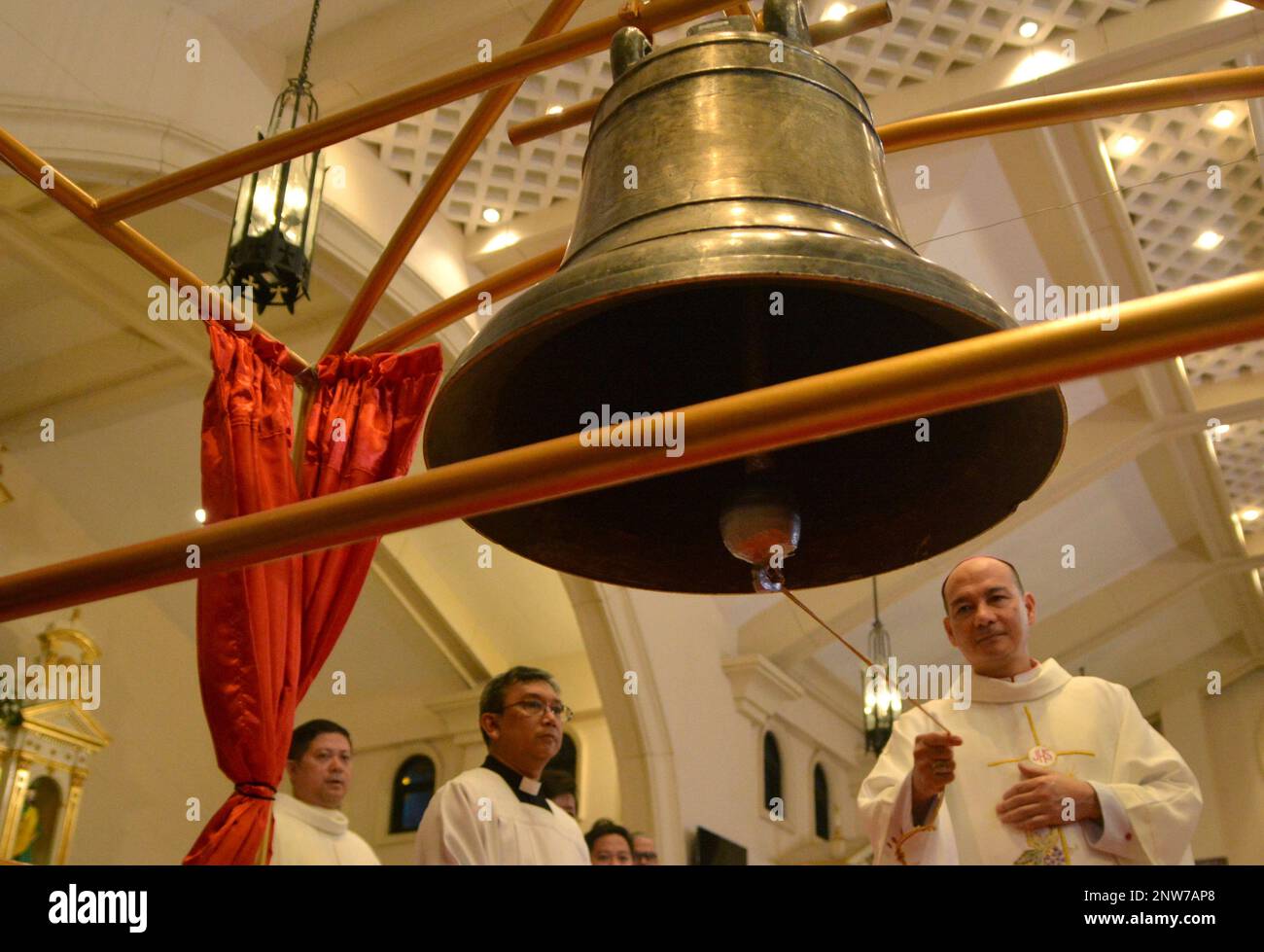 Roman Catholic Bishop Rex Ramirez, makes the ceremonial tolling of one ...
