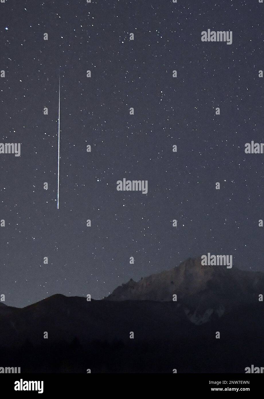 A photo shows a shooting star of the Gemini meteor swarm above ...