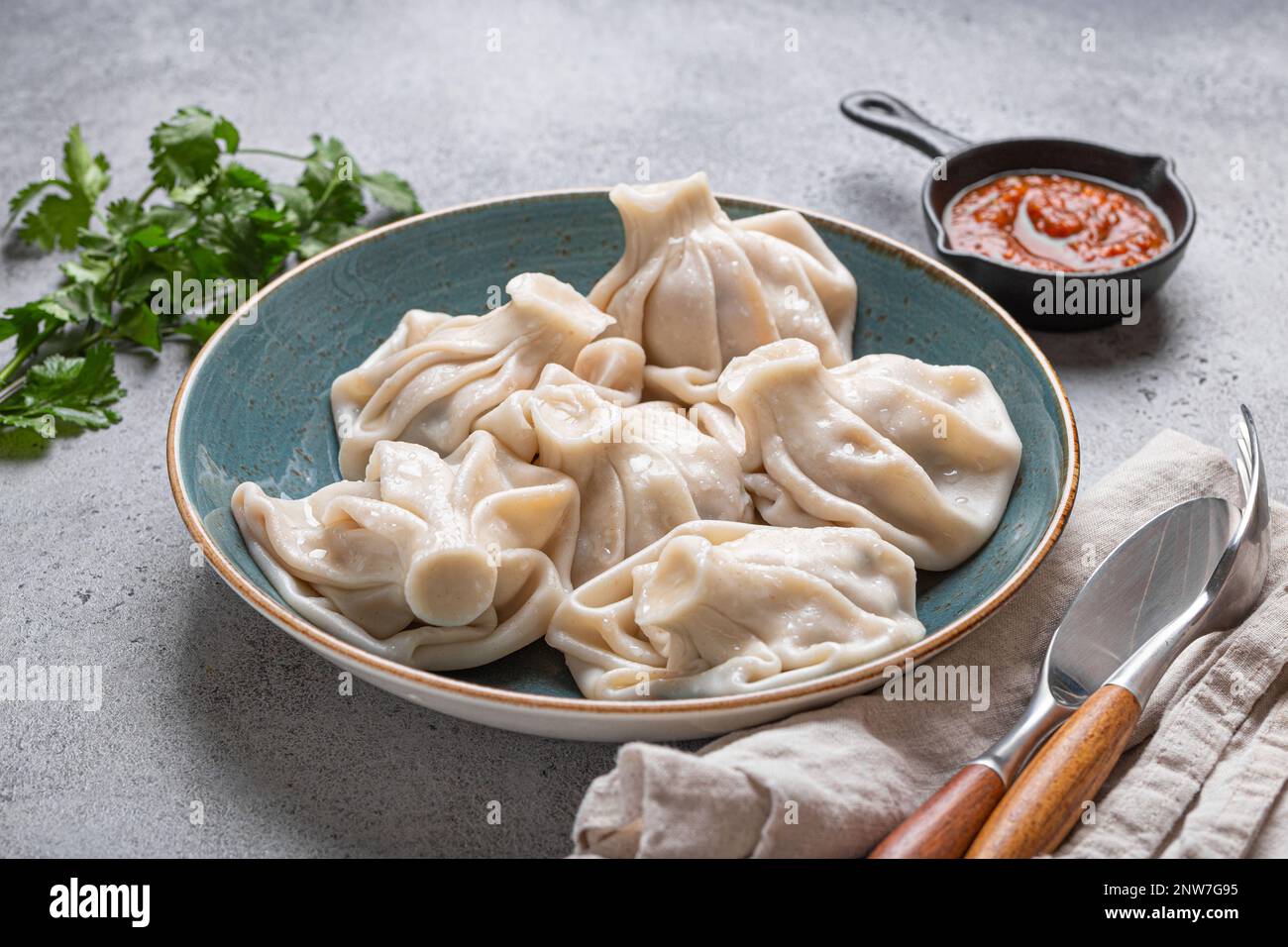 Georgian dumplings Khinkali on plate with red tomato sauce and fresh ...