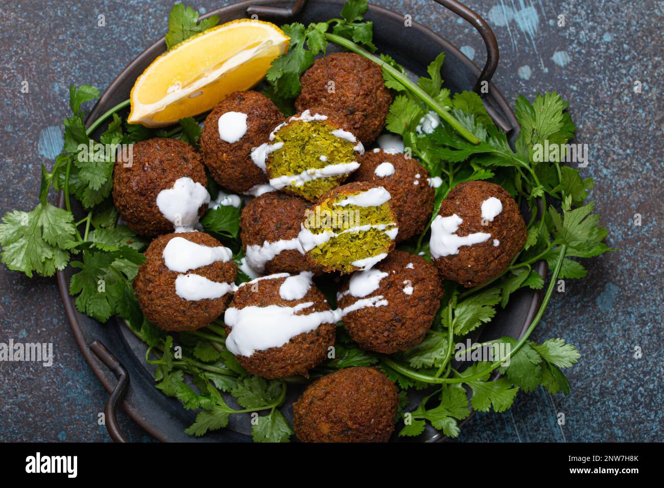Plate of fried falafel balls served with fresh green cilantro and lemon ...