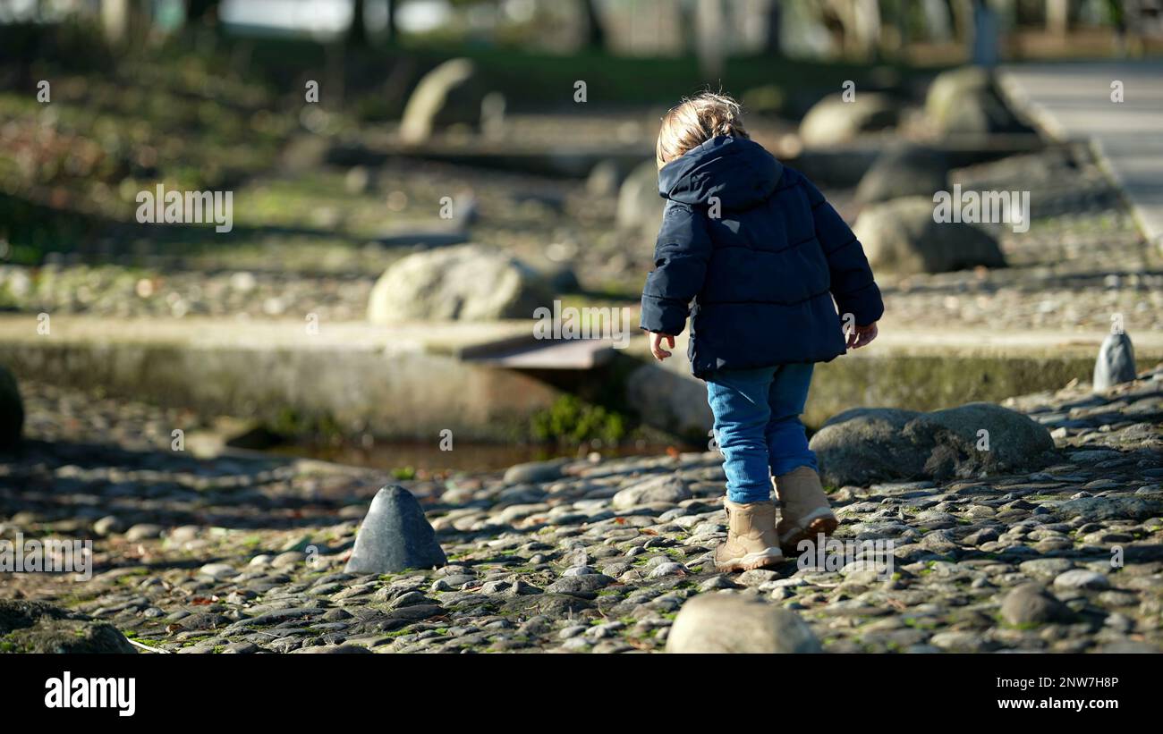 One carefree small boy playing outside at city park. Child exploring ...