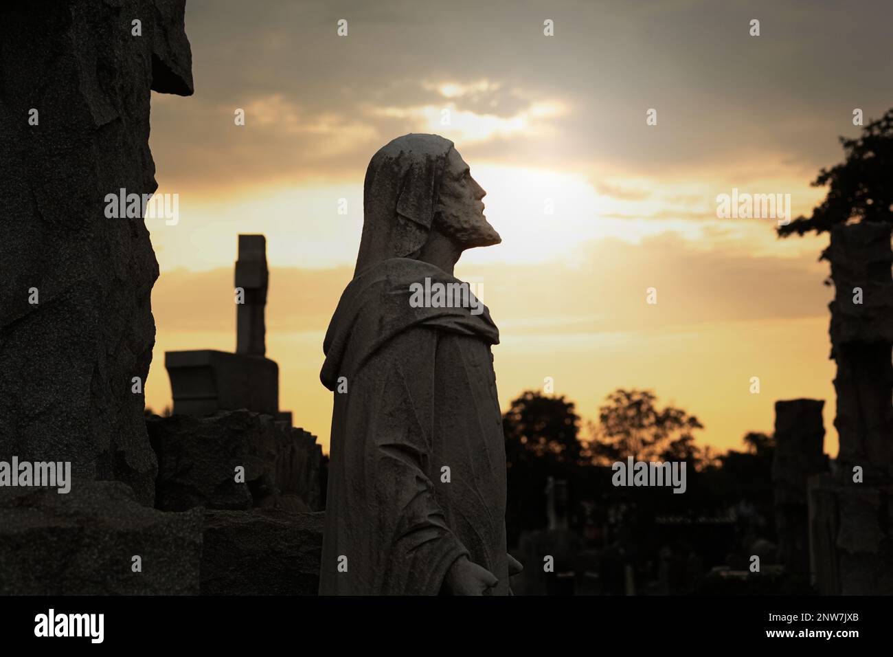 Weathered old marble statue of Jesus Christ is shadows against the ...