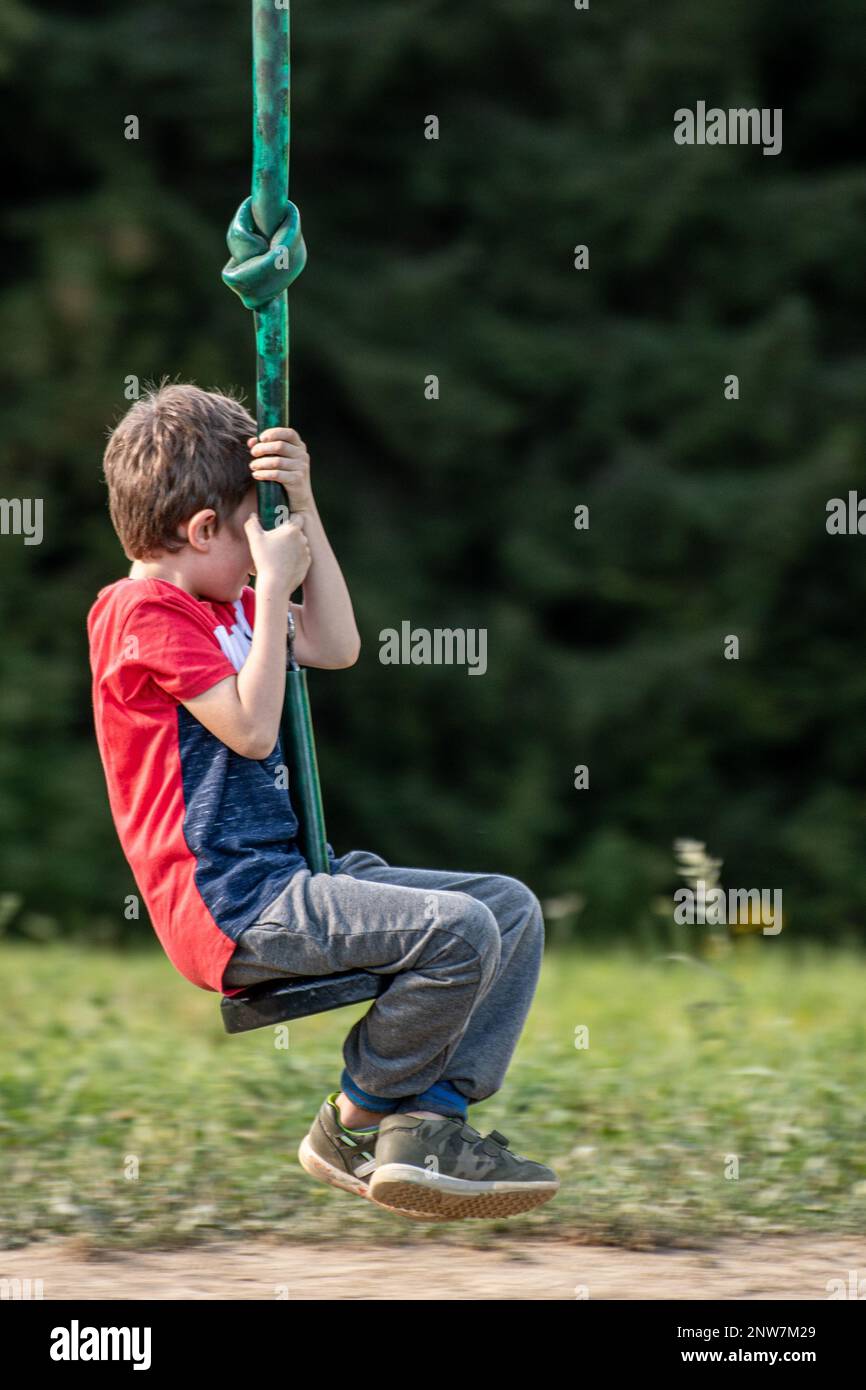Child having fun on the zip line in the park Stock Photo - Alamy
