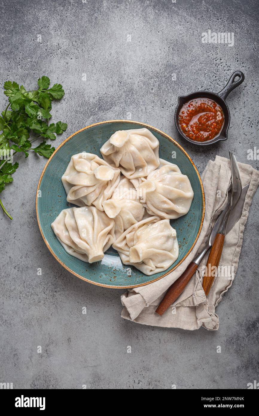 Georgian dumplings Khinkali on plate with red tomato sauce and fresh ...