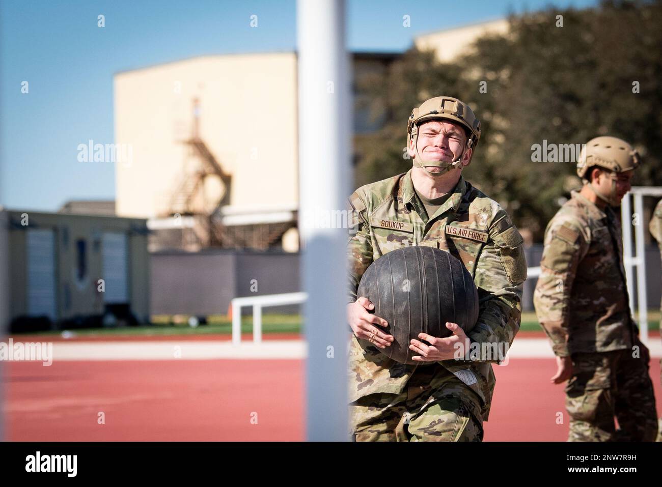 Special Warfare candidates carry and throw weights in a relay race as ...