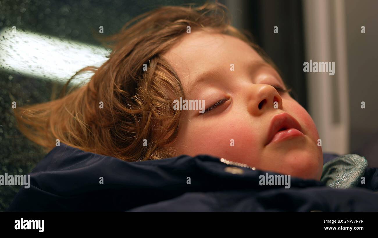 Candid child sleeping in train. Closeup small boy asleep on mother lap ...