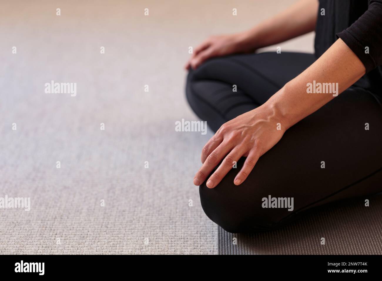 Horizontal side closeup of lower body of yogini on the floor with legs ...