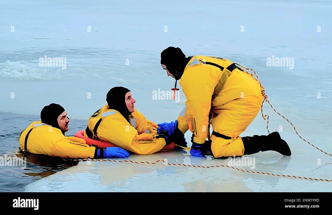 Firefighters wearing cold-water immersion protective suits hold surface ...