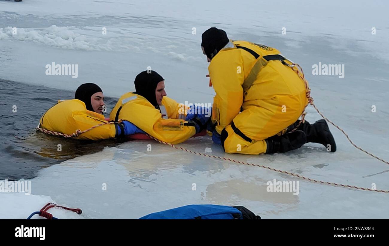 Firefighters wearing cold-water immersion protective suits hold surface ...