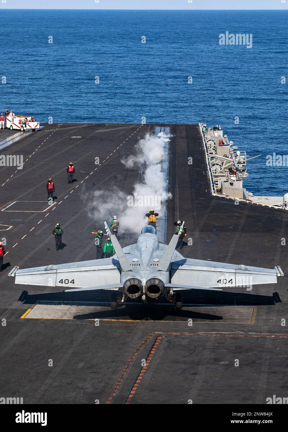 230214-N-EL850-2140 MEDITERRANEAN SEA (Feb. 14, 2023) A Sailor directs an F/A-18E Super Hornet ...