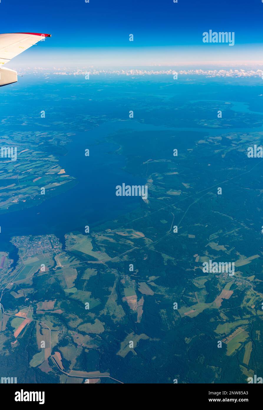 Aerial view from airplane window above green ground. View from the ...