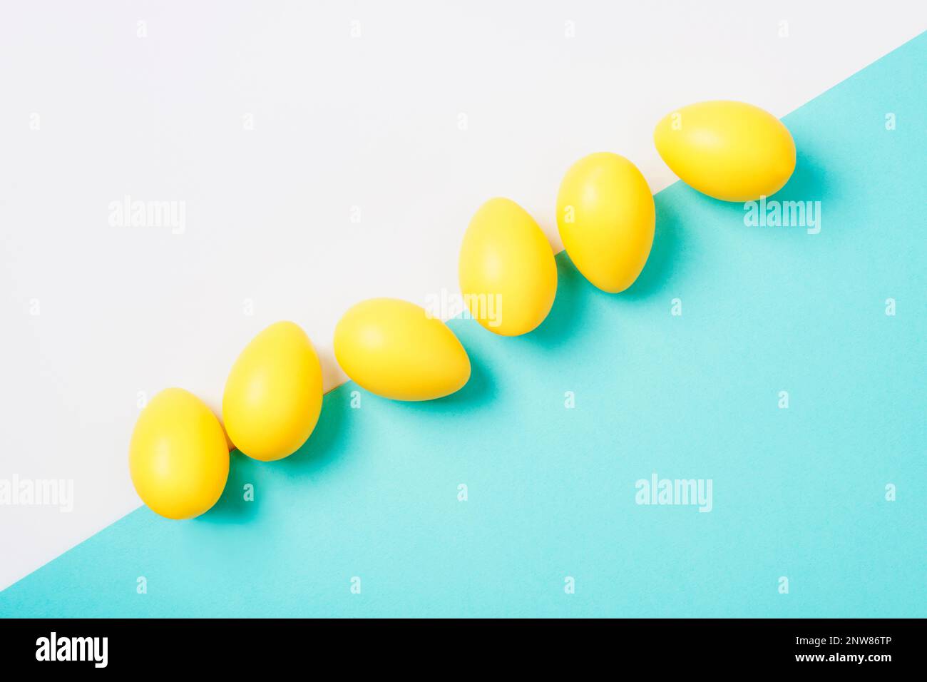 Yellow Easter eggs on white and blue background. Top view, flat lay, copy space Stock Photo - Alamy