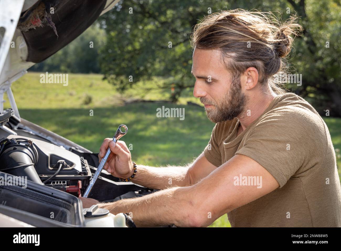 Man repairing a van outdoors in nature Stock Photo - Alamy
