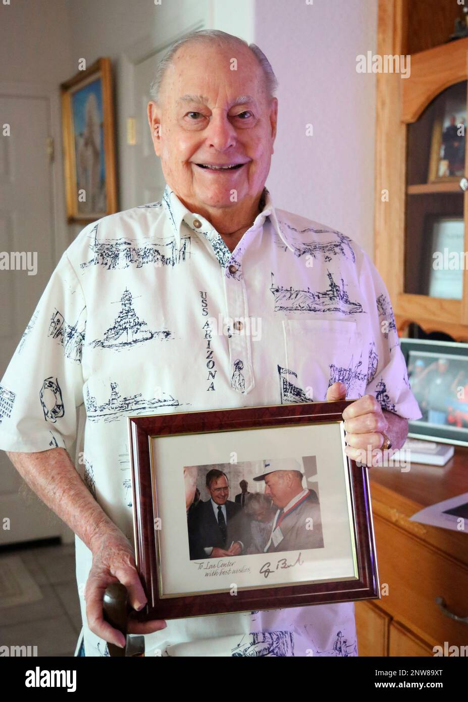 World War II and USS Arizona survivor Louis A. Conter, holds a photo of ...