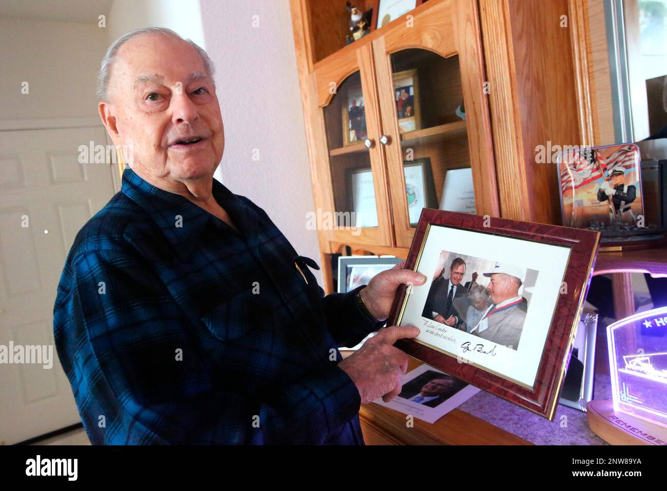 World War II and USS Arizona survivor Louis A. Conter, holds a photo of ...