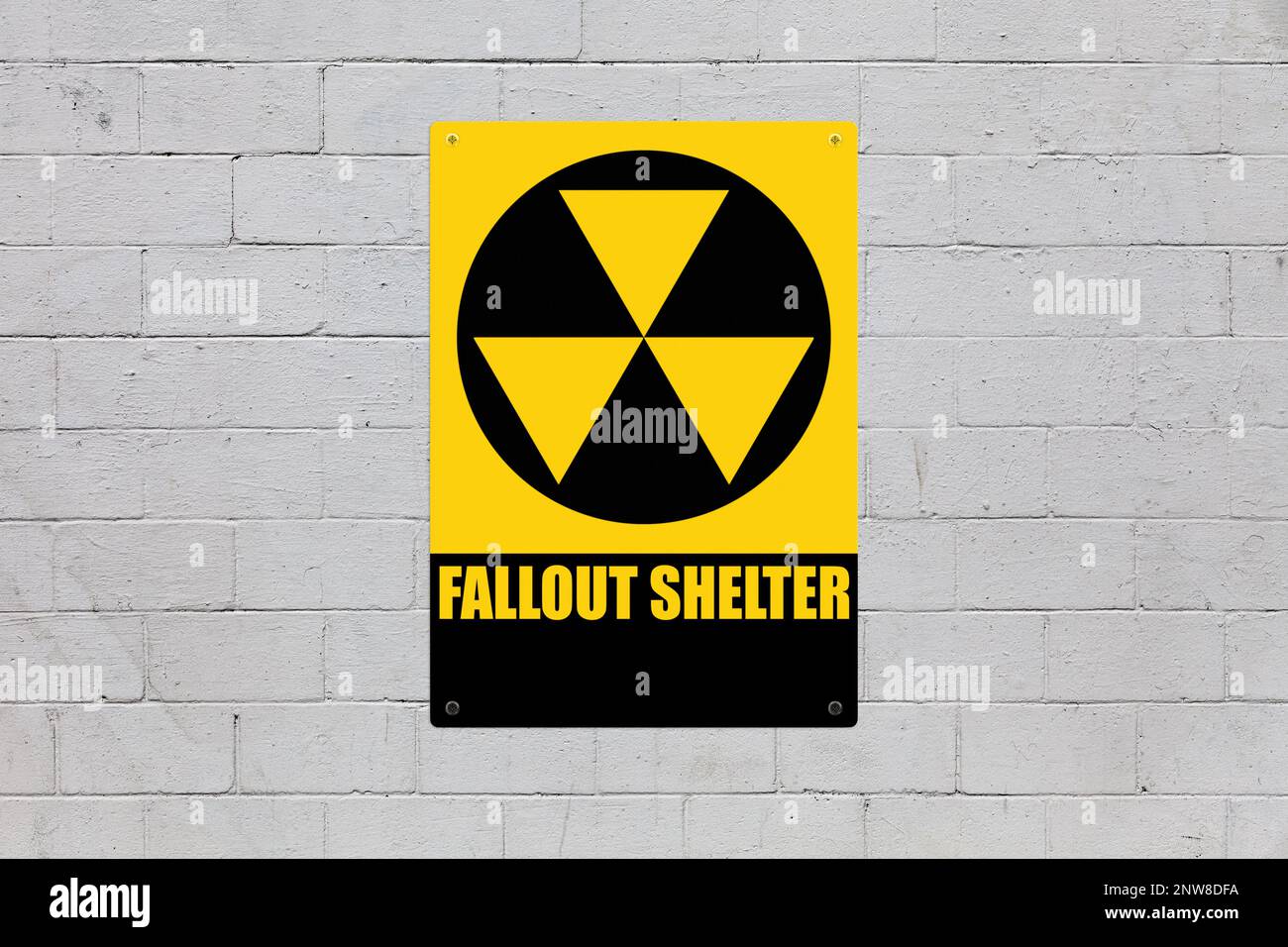 Yellow warning sign screwed to a brick wall to warn about a threat. In ...