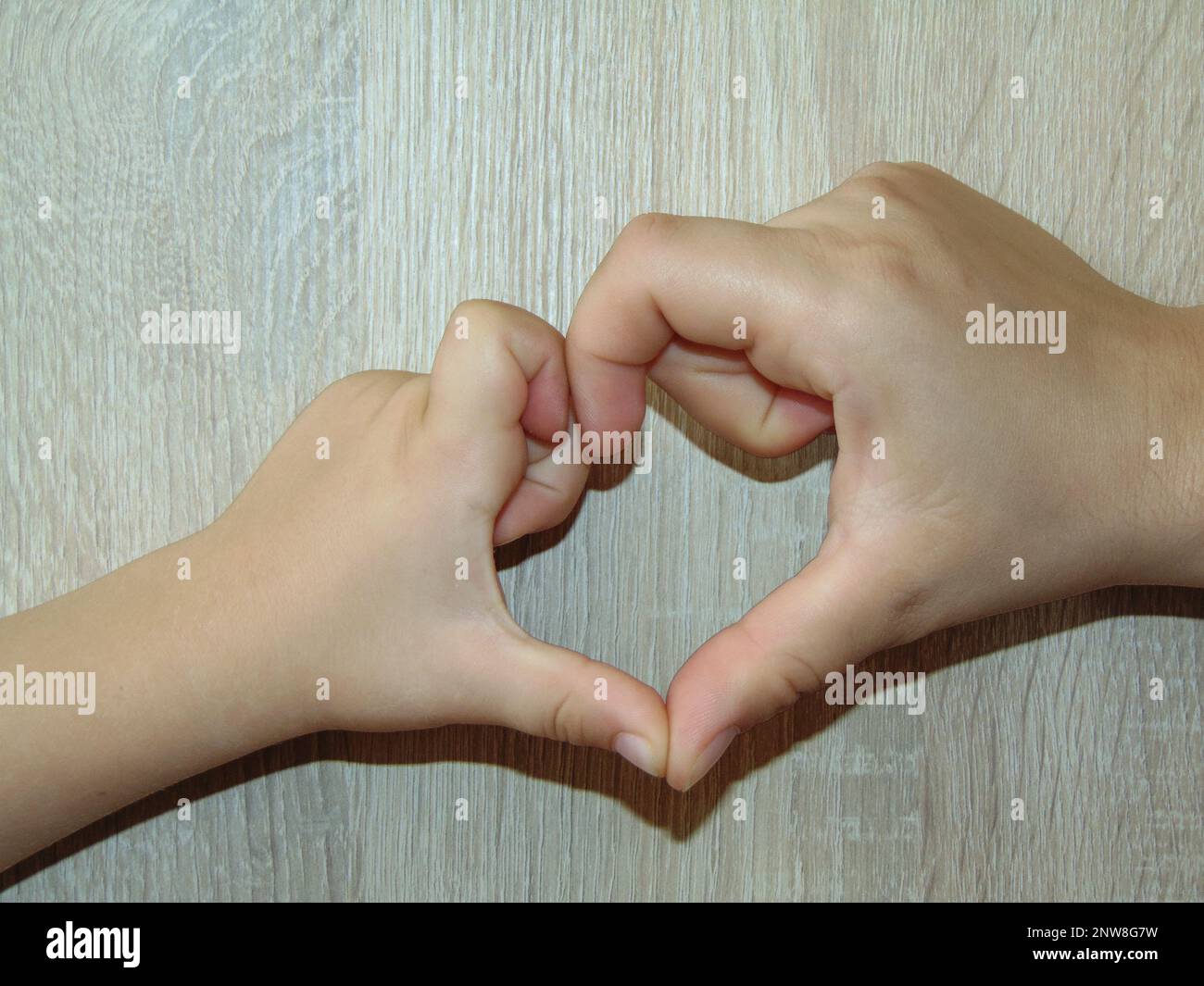 a mother and her child form a heart from their fingers. Love concept ...