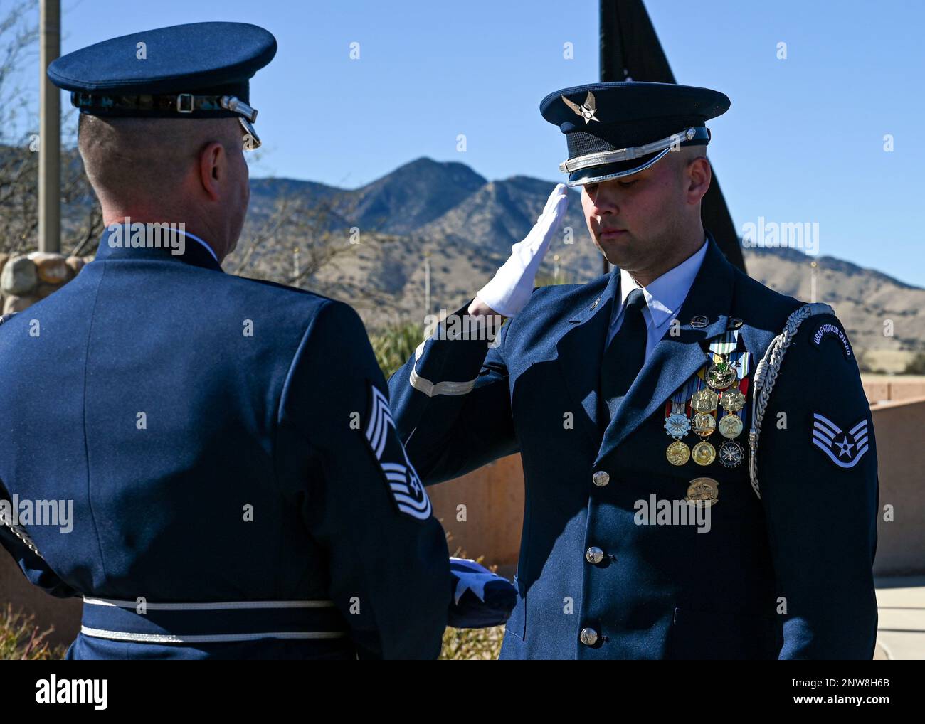 A member of the U.S. Air Force Honor Guard salutes the American flag ...