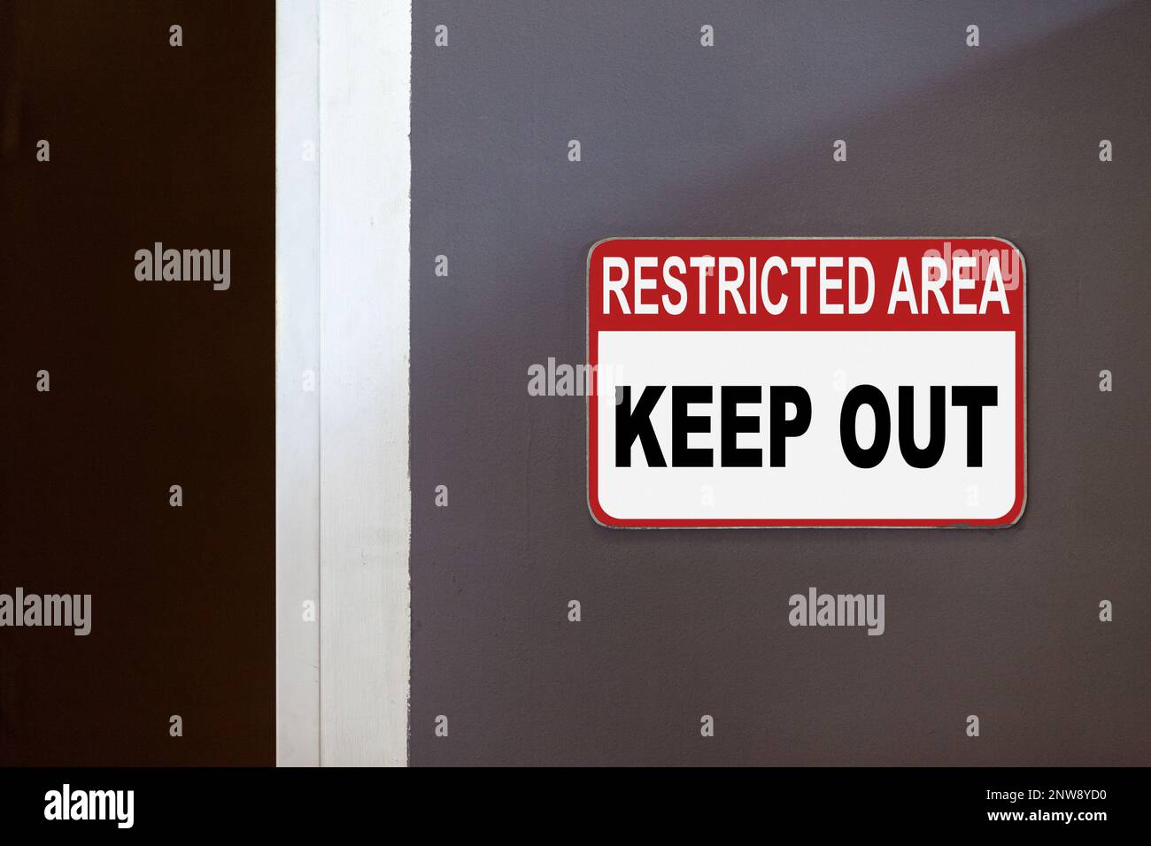 Red and white restricted area sign on the side of an open door stating ... Red and white restricted area sign on the side of an open door stating ...