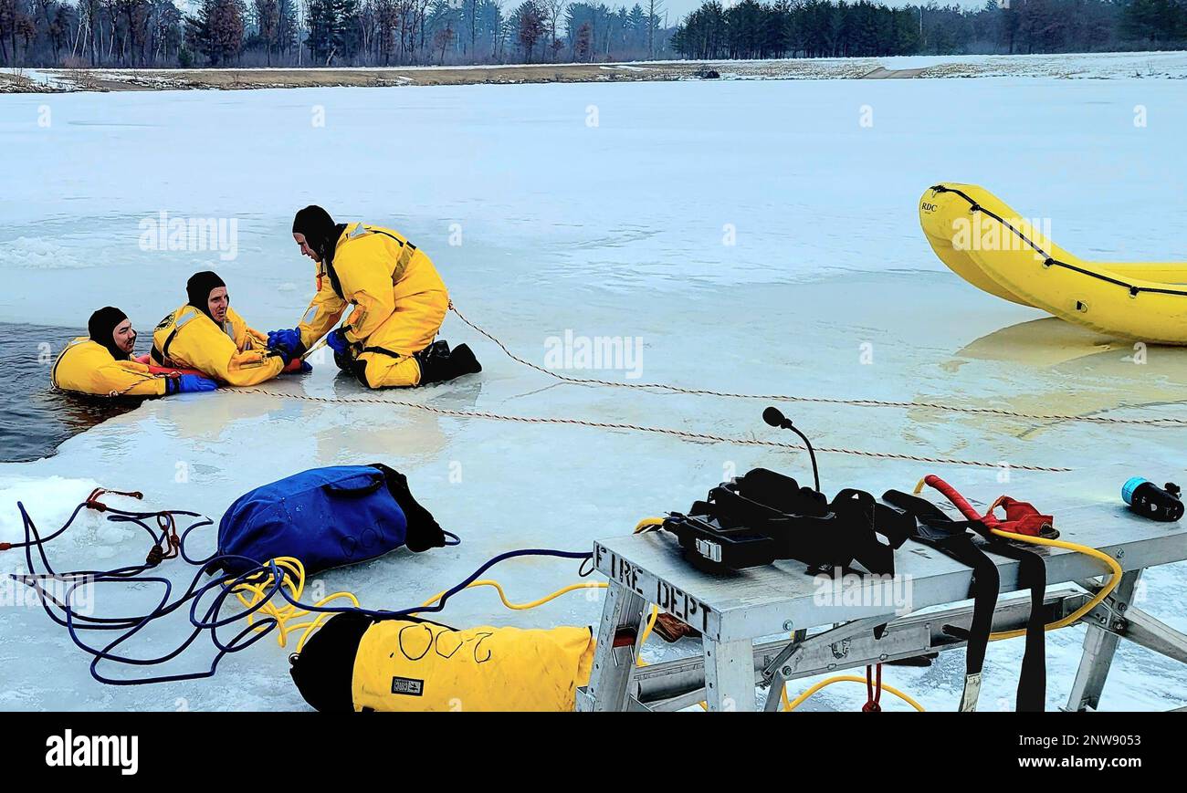 Firefighters wearing cold-water immersion protective suits hold surface ...