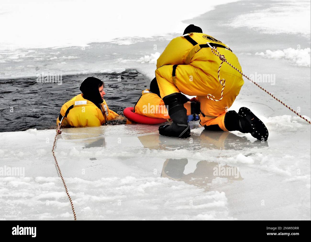 Firefighters wearing cold-water immersion protective suits hold surface ...