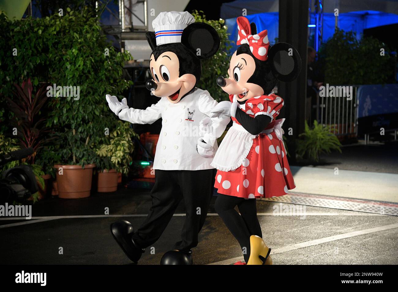 Actors dressed as Mickey Mouse and Minnie Mouse stand at the finish ...