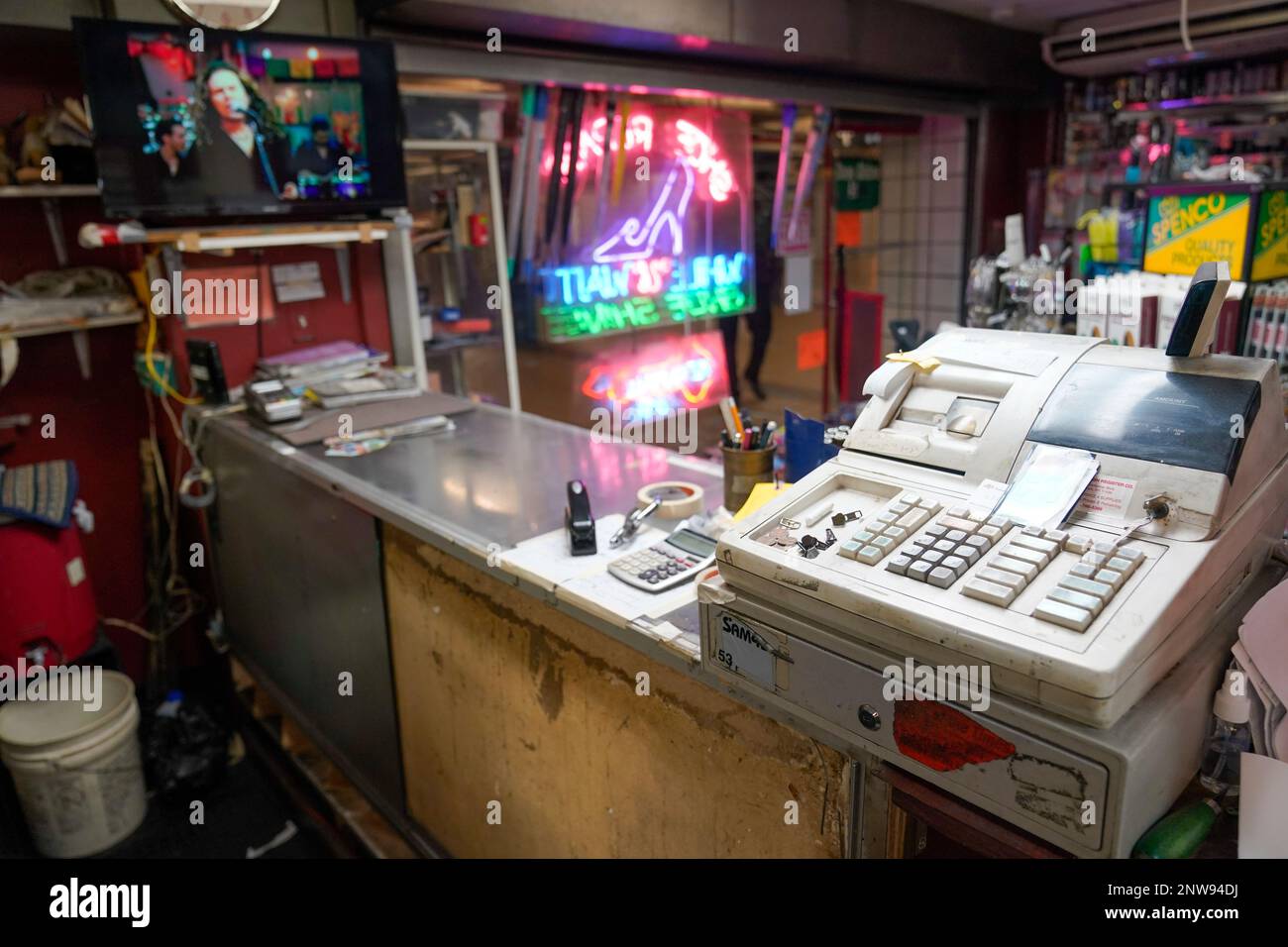 A cash register is seen on the front counter at the Alpha Shoe Repair ...