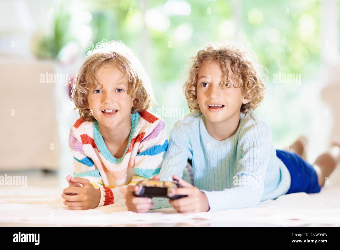Kids play video game. Children with remote controller. Boy in sunny ...