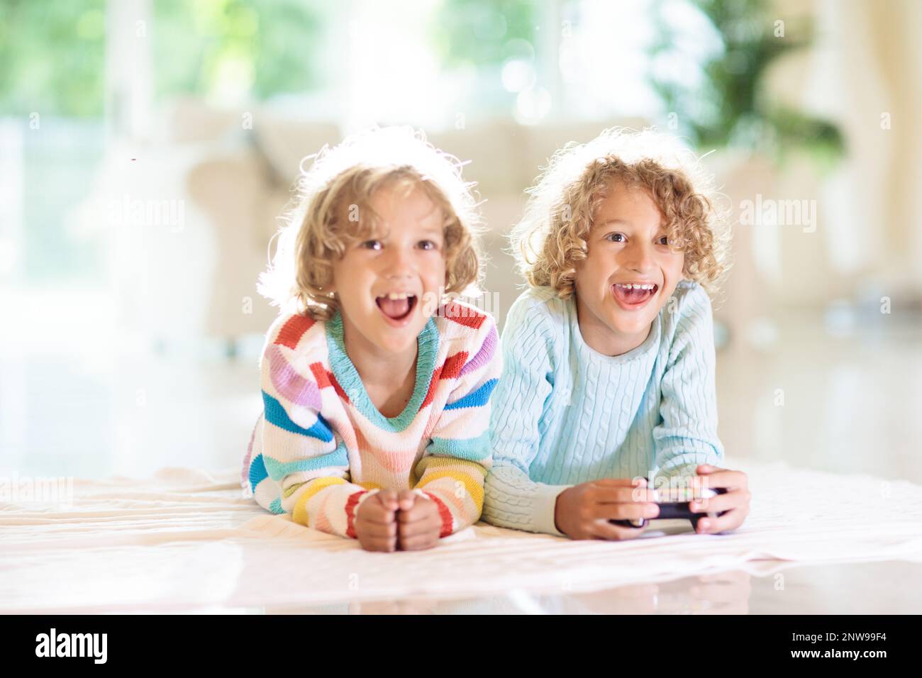 Kids play video game. Children with remote controller. Boy in sunny ...