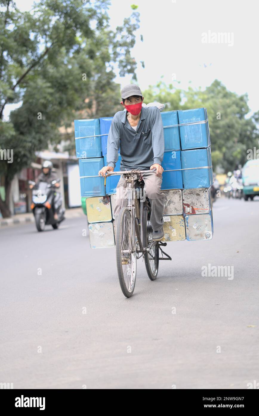 delivery man carrying large package, jakarta, indonesia Stock Photo - Alamy
