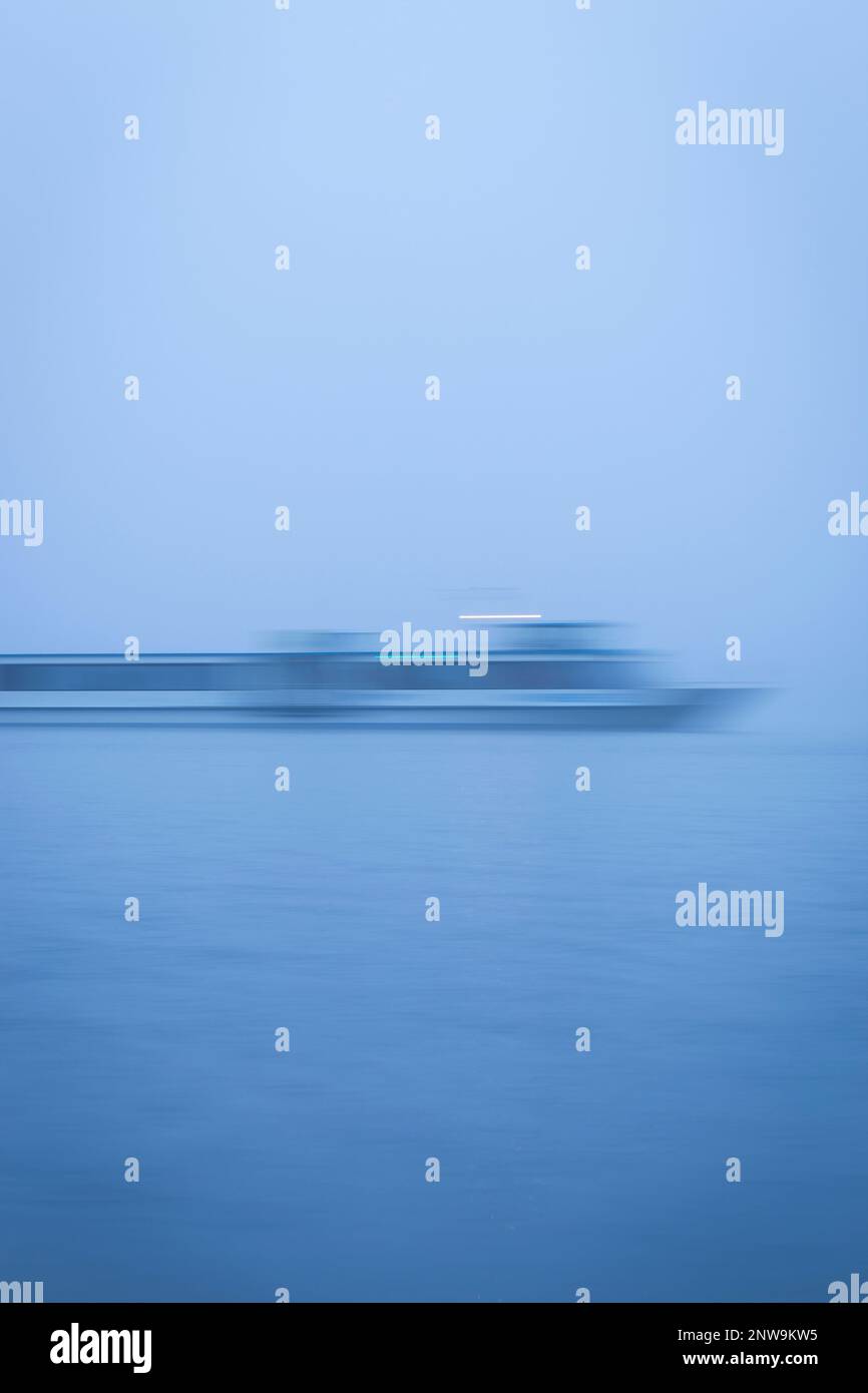 Long exposure vertical action shot of a ghostly moving boat figure ...