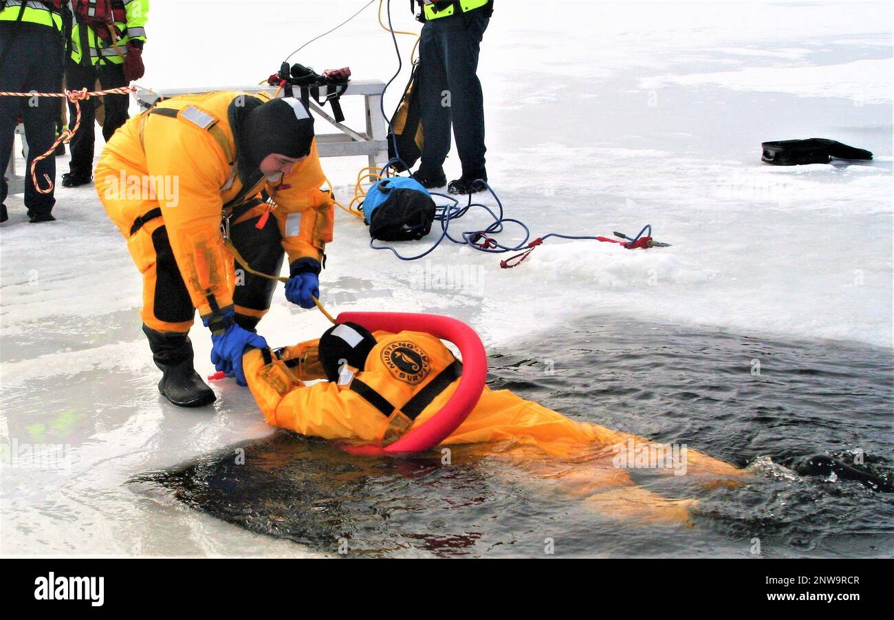 Firefighters wearing cold-water immersion protective suits hold surface ...