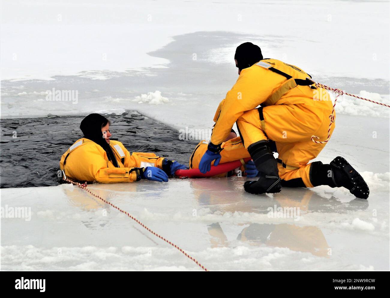 Firefighters wearing cold-water immersion protective suits hold surface ...
