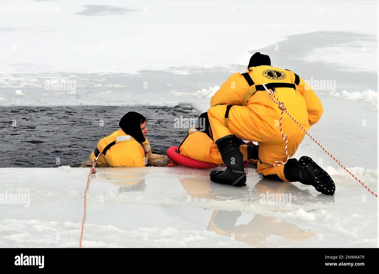 Firefighters wearing cold-water immersion protective suits hold surface ...