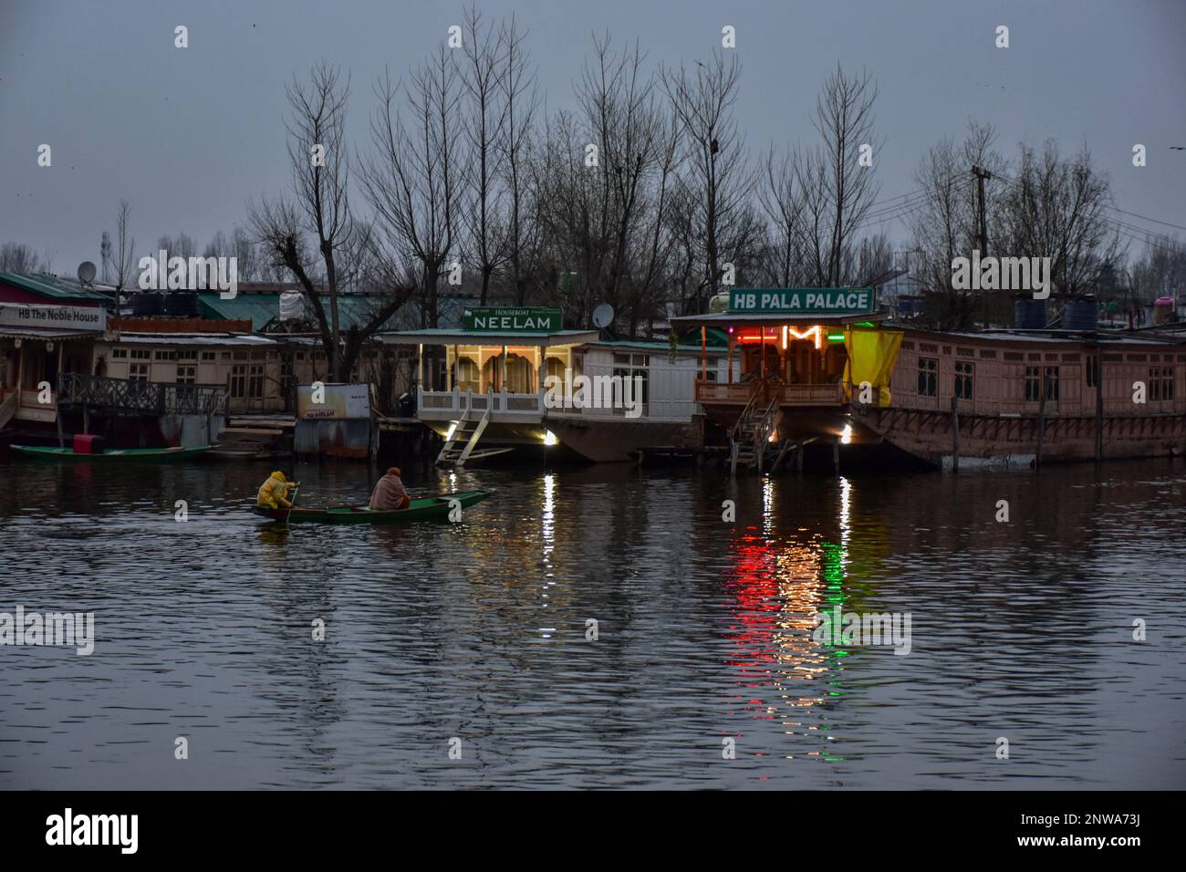 Srinagar, India. 28th Feb, 2023. A boatman ferries a passenger across the world famous Dal lake ...