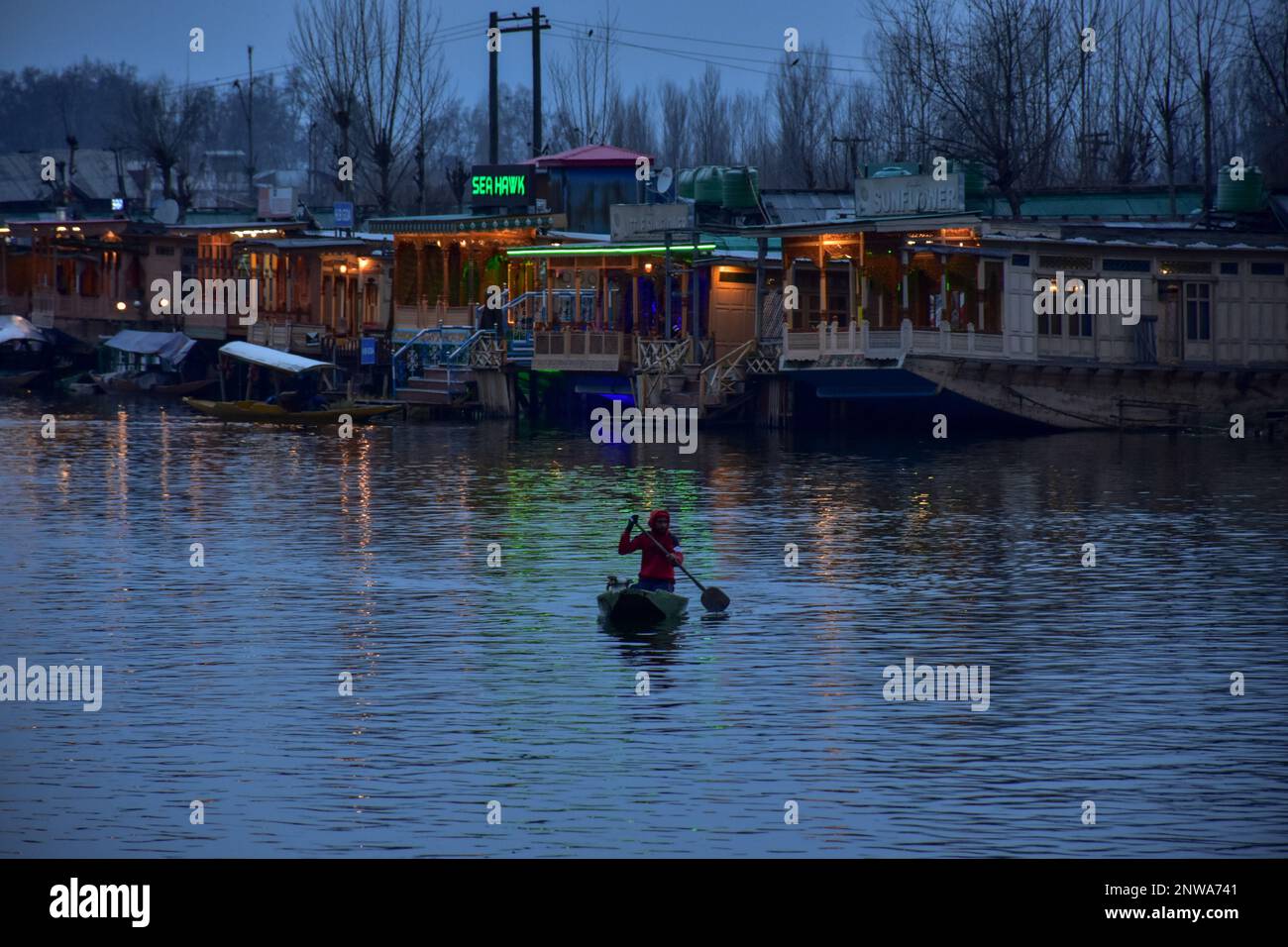 Srinagar, India. 28th Feb, 2023. A boatman rows his boat across the world famous Dal lake during ...