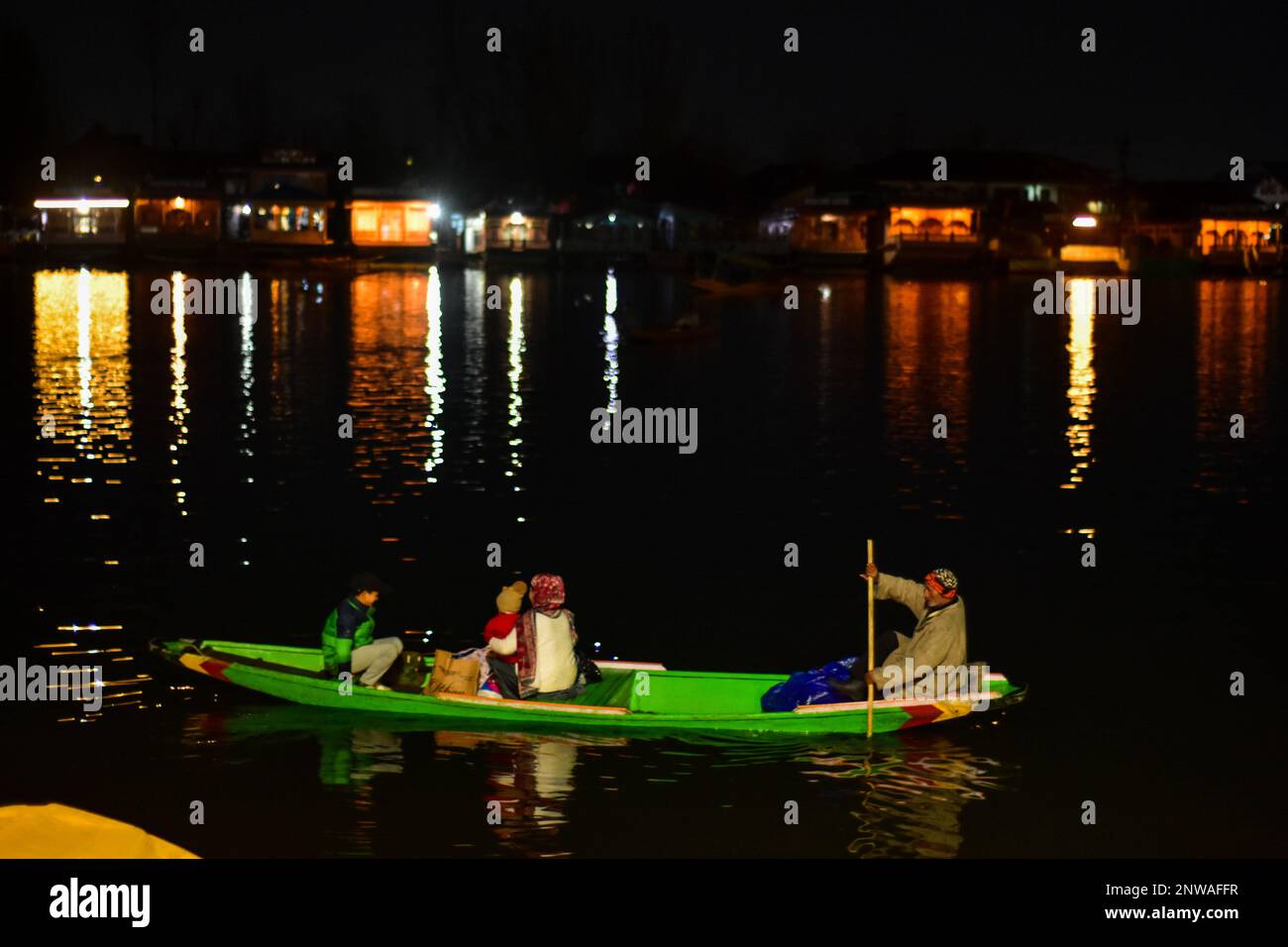 Srinagar, Kashmir, India. 28th Feb, 2023. A boatman ferries passengers on his boat across the ...
