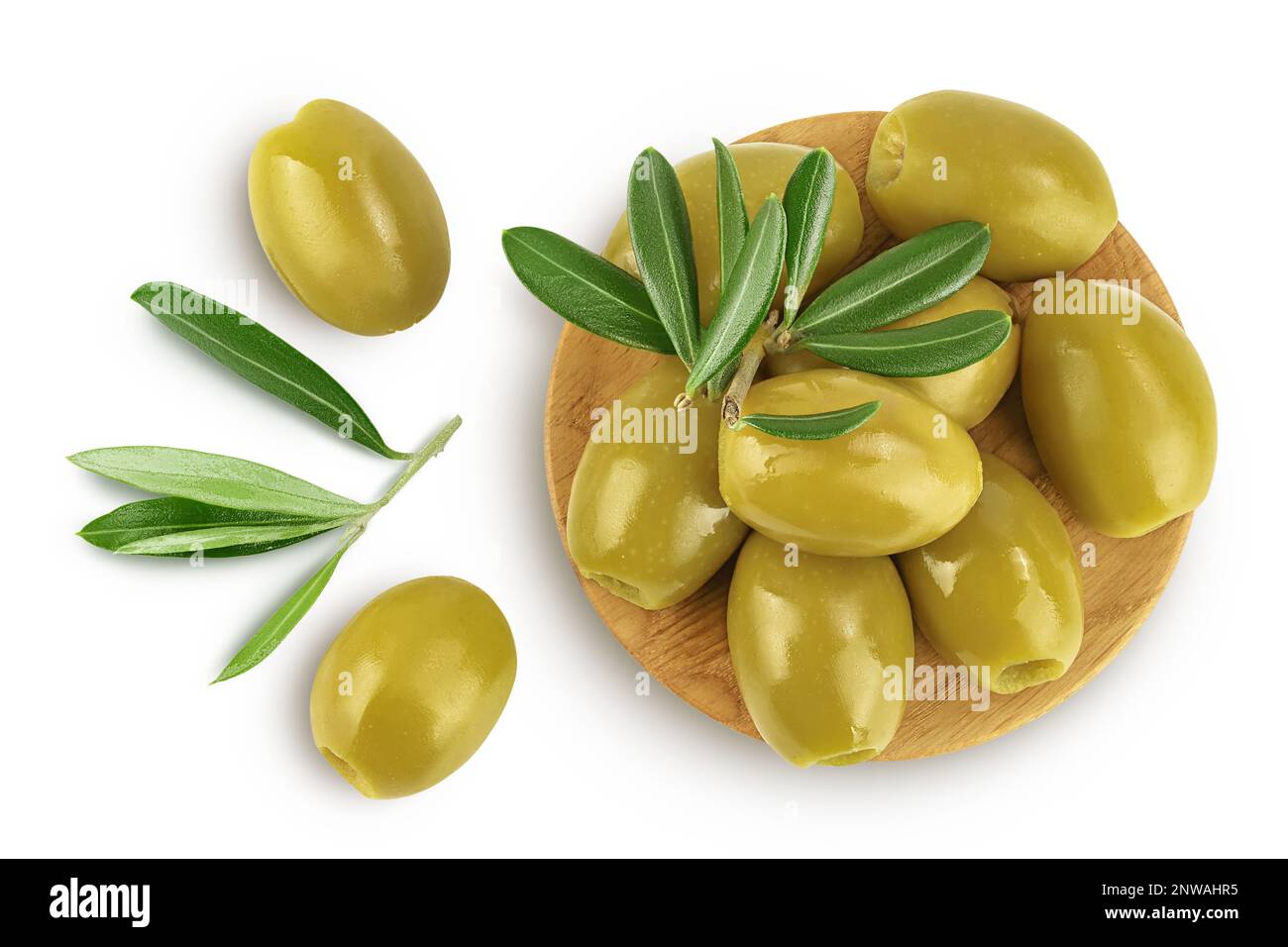 Green olives with leaves in wooden bowl isolated on a white background ...