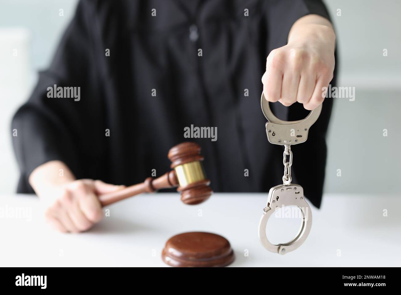 Judge with wooden gavel and holding handcuffs Stock Photo - Alamy