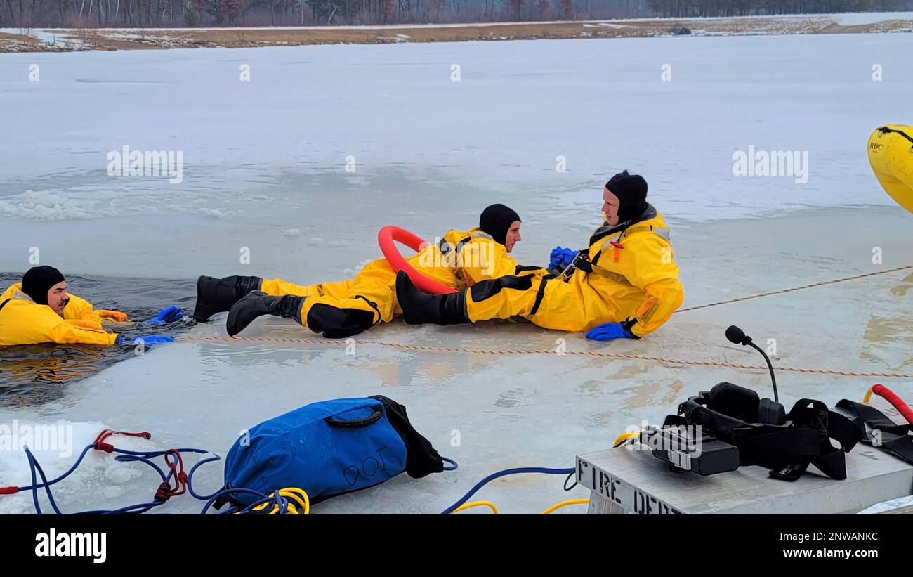 Firefighters wearing cold-water immersion protective suits hold surface ...